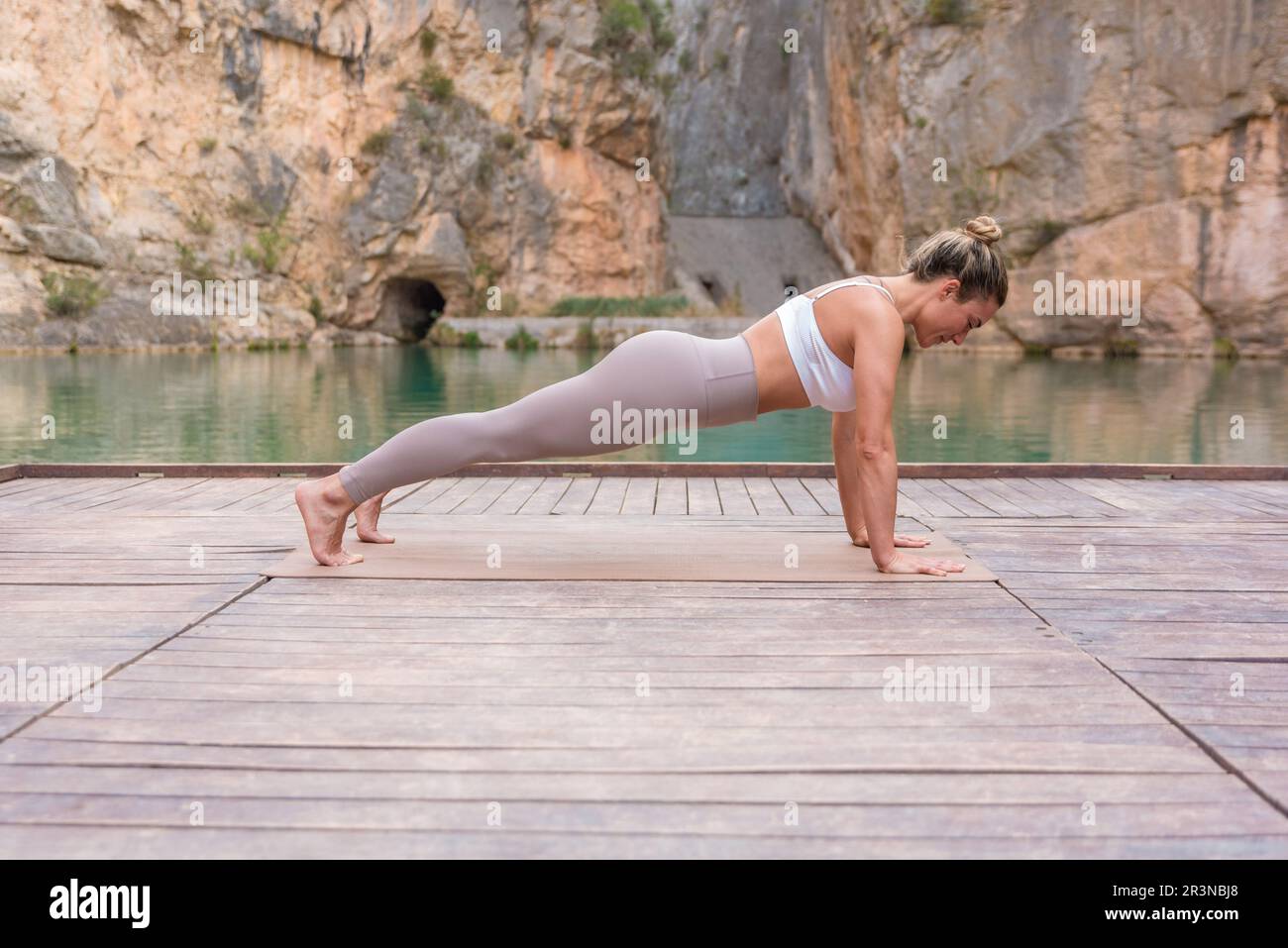 Full body side view of fit young woman in sportswear doing plank ...