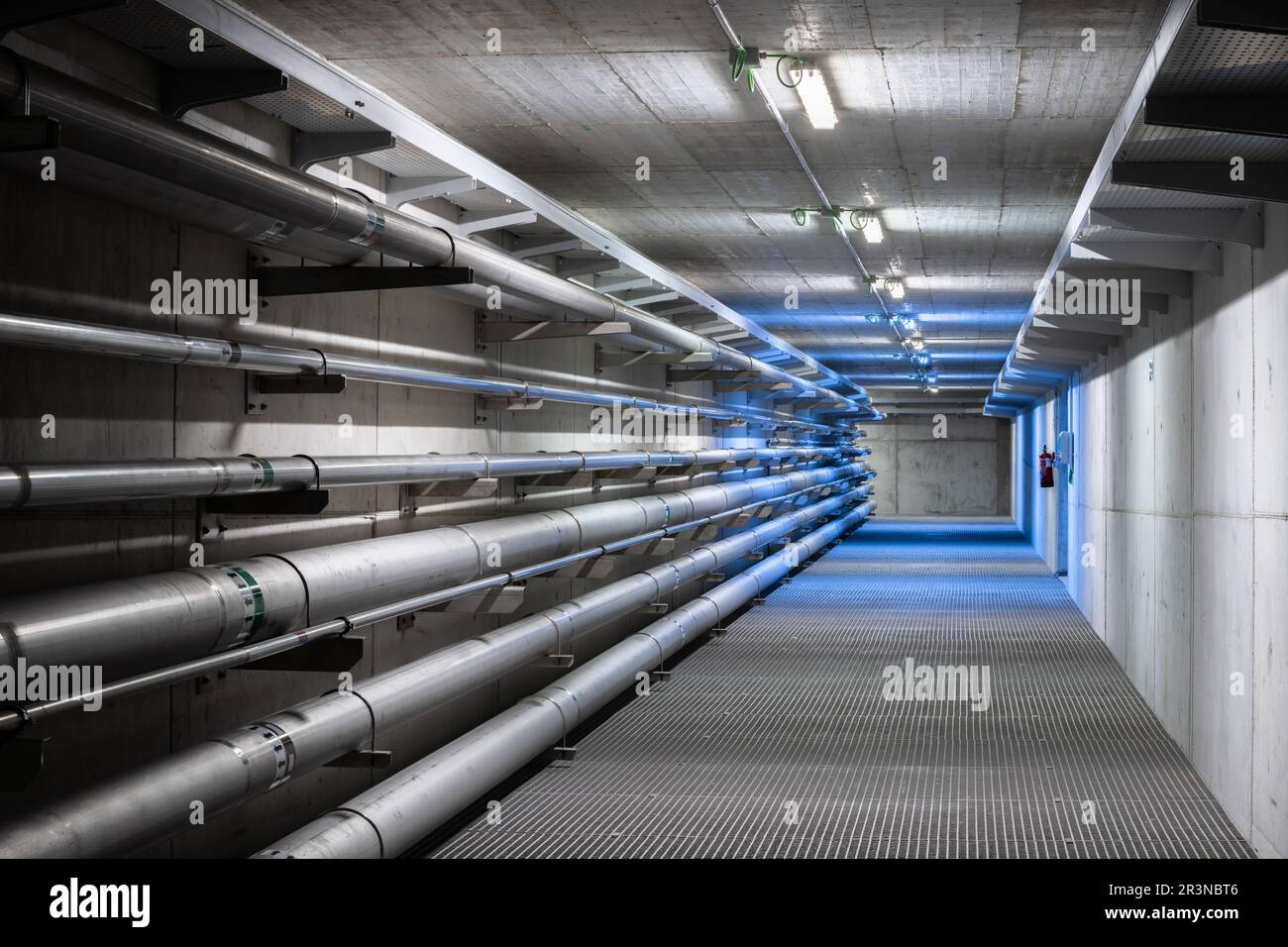 Empty underground corridor with drainage system and metal pipelines for ...