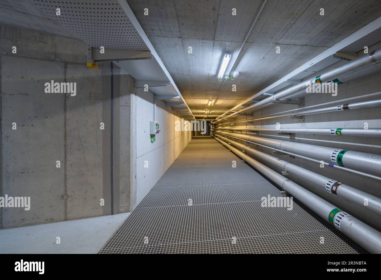 Long empty underground corridor with drainage system and metal ...