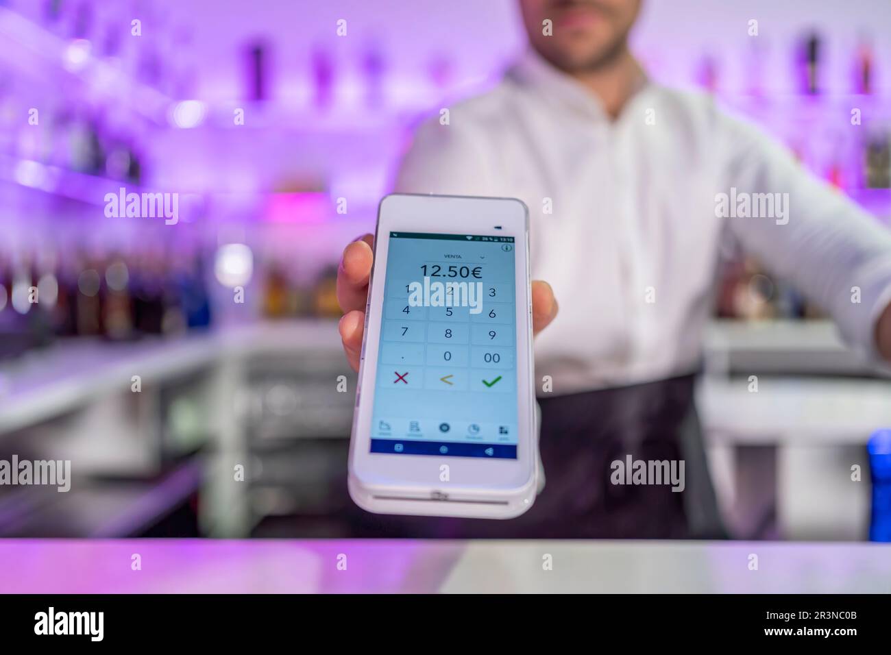 Unrecognizable male bartender showing digital POS machine screen with ...