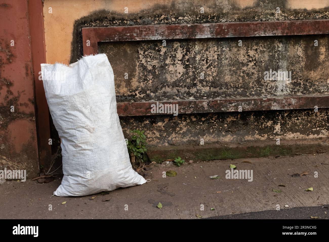 A white soil bag stands amidst lush green surroundings, creating a ...
