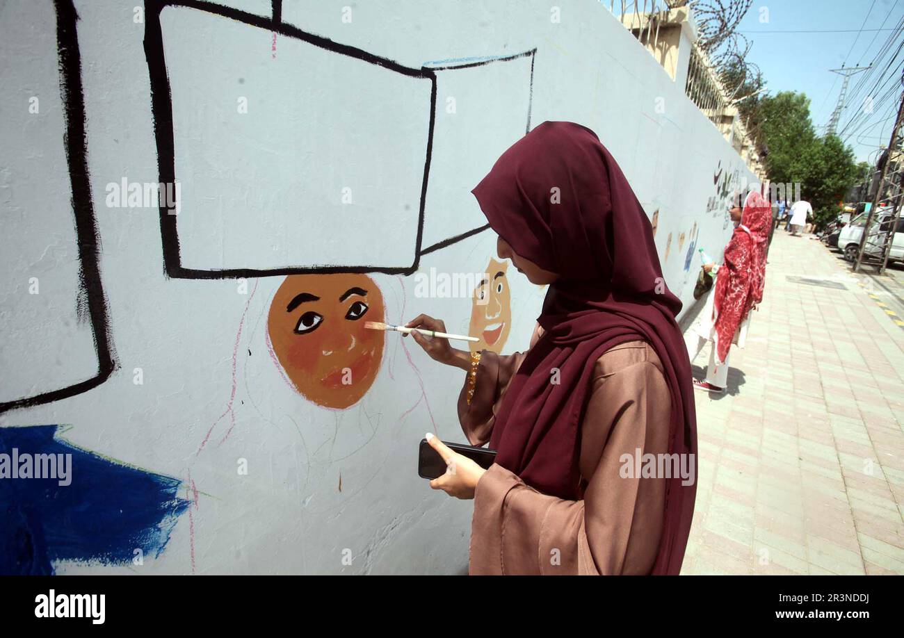 Fine artists busy in painting on a wall of Pakistan Post Office to show ...