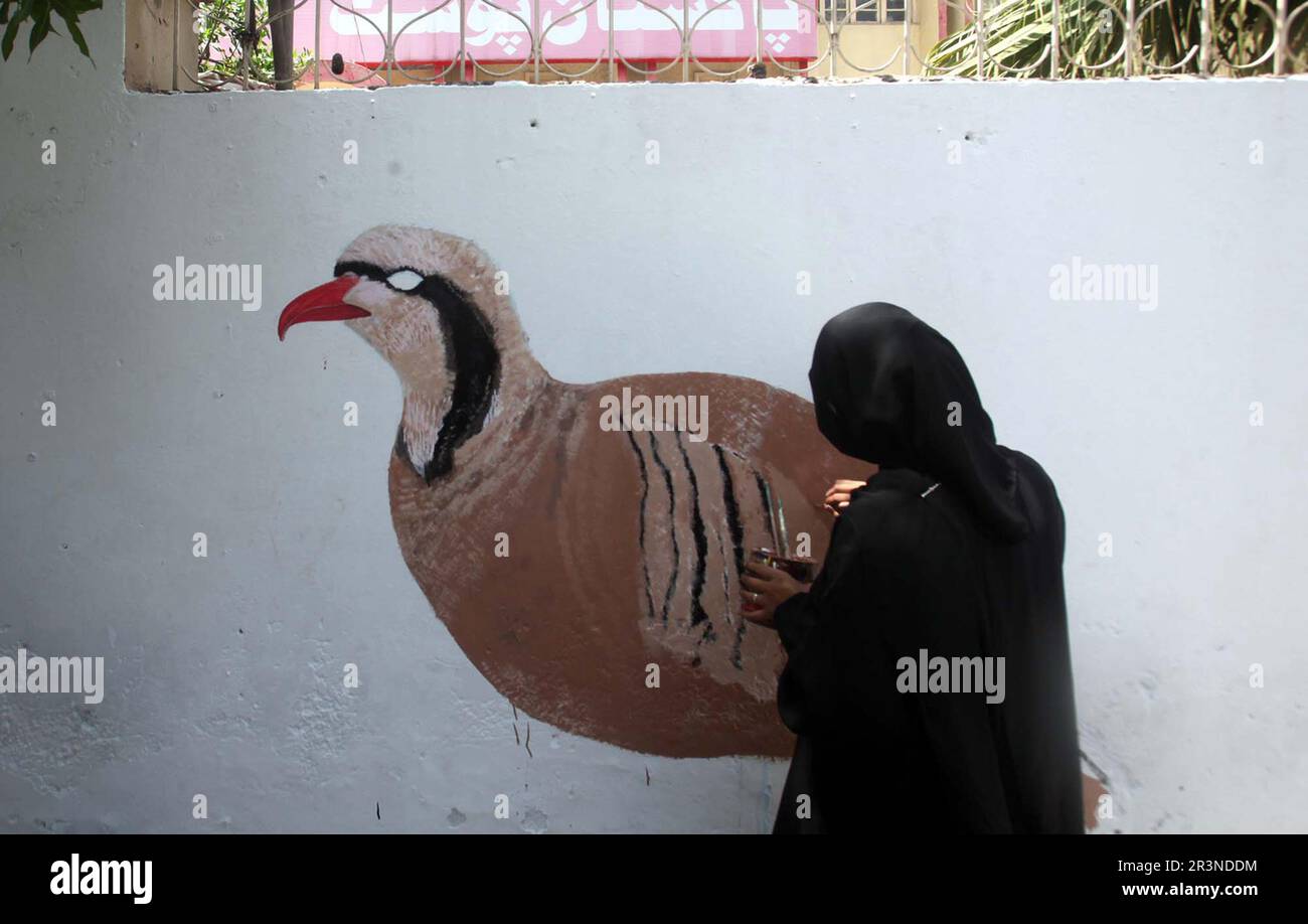 Fine artists busy in painting on a wall of Pakistan Post Office to show ...