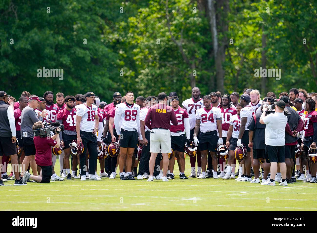The Washington Commanders listen to head coach Ron Rivera, center, as ...