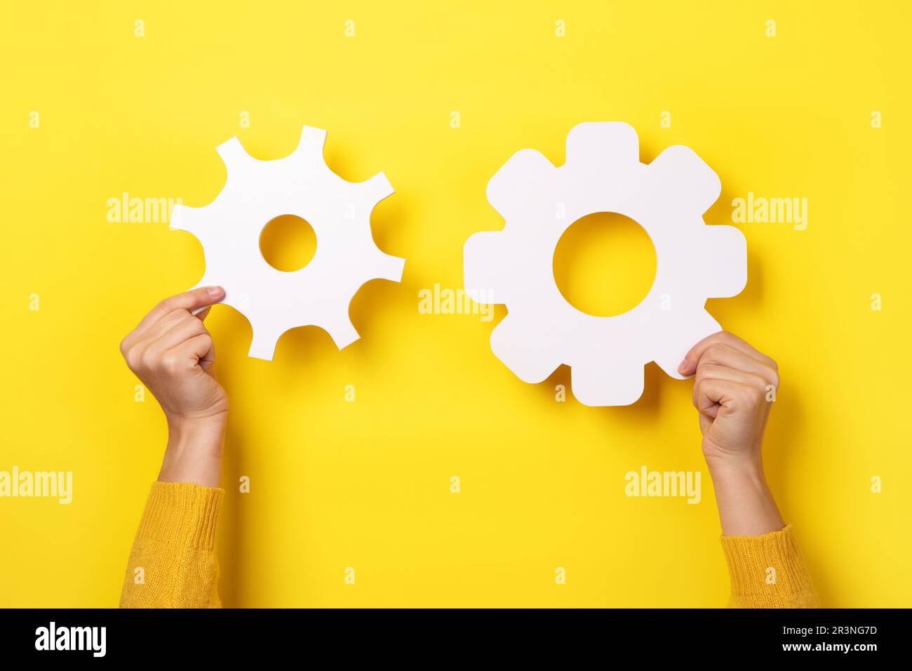 Gear symbol in hands Stock Photo - Alamy