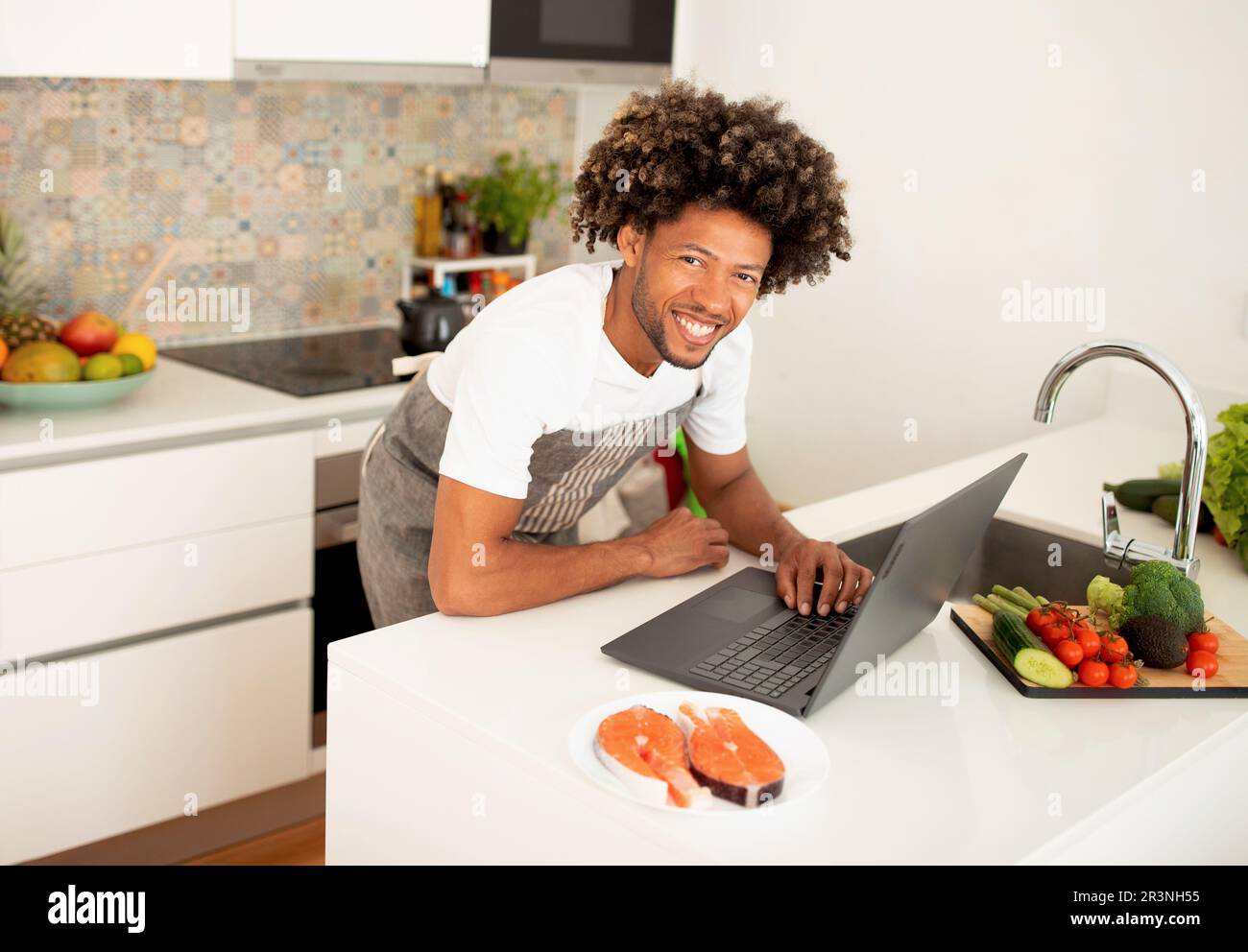 Happy Black Guy Cooking Near Laptop Posing In Kitchen Indoor Stock ...