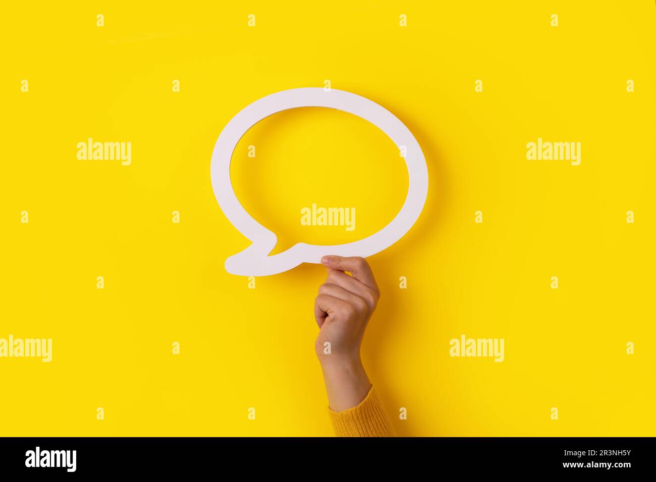 Hand holding dialogue bubble Stock Photo - Alamy