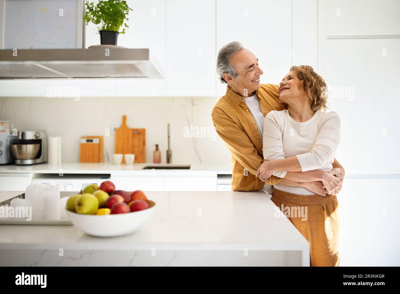 Romantic married senior spouses embracing in kitchen, loving old couple ...