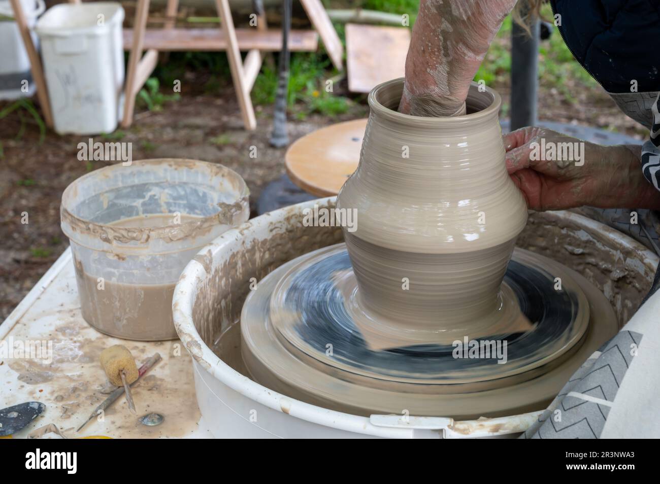 Making of mud pot on potters wheel during workshop outdoor in ...