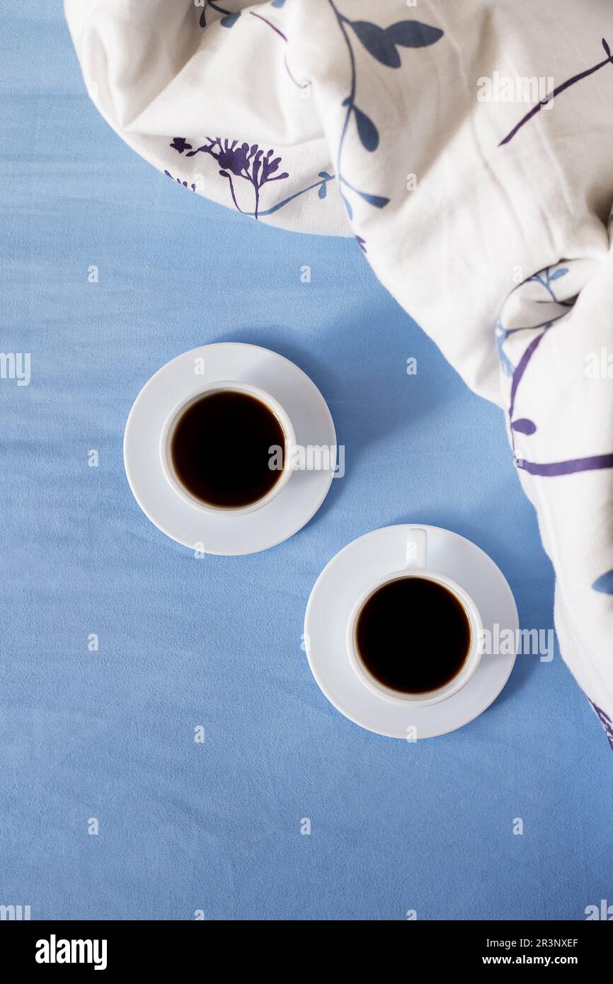 Two white cups of coffee are in bed Stock Photo - Alamy