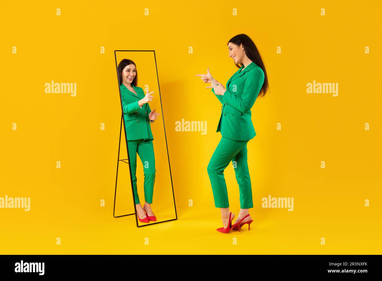 Trendy lady pointing at her reflection in mirror posing after ...