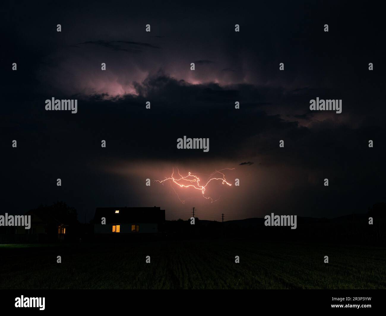 Nighttime lightning storm with house Stock Photo - Alamy