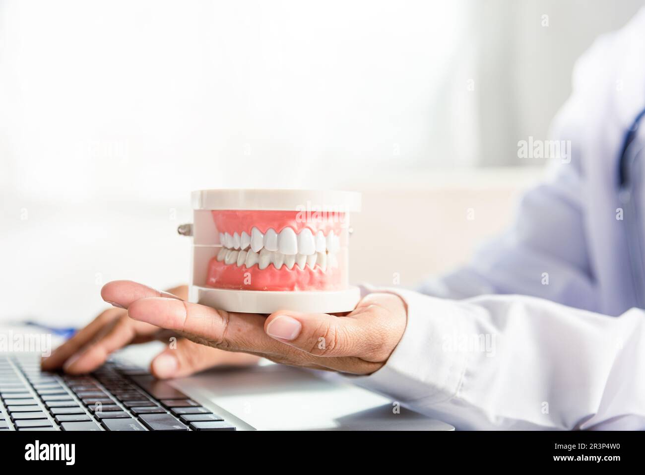 Female doctor sitting and hold tooth on desk at clinic office have ...