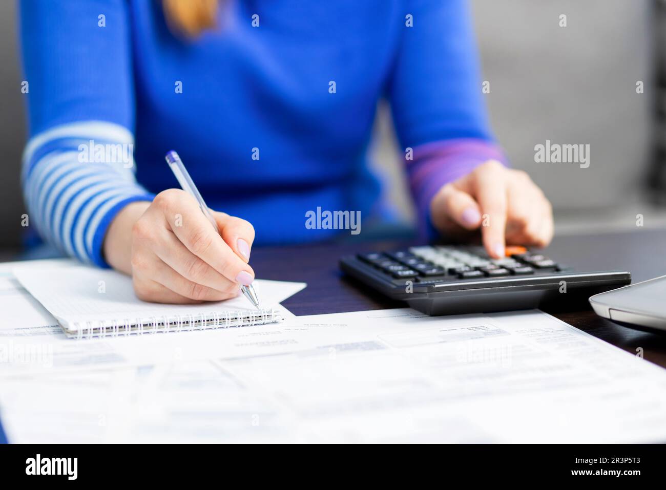Woman using calculator for calculate domestic bills at home, doing ...