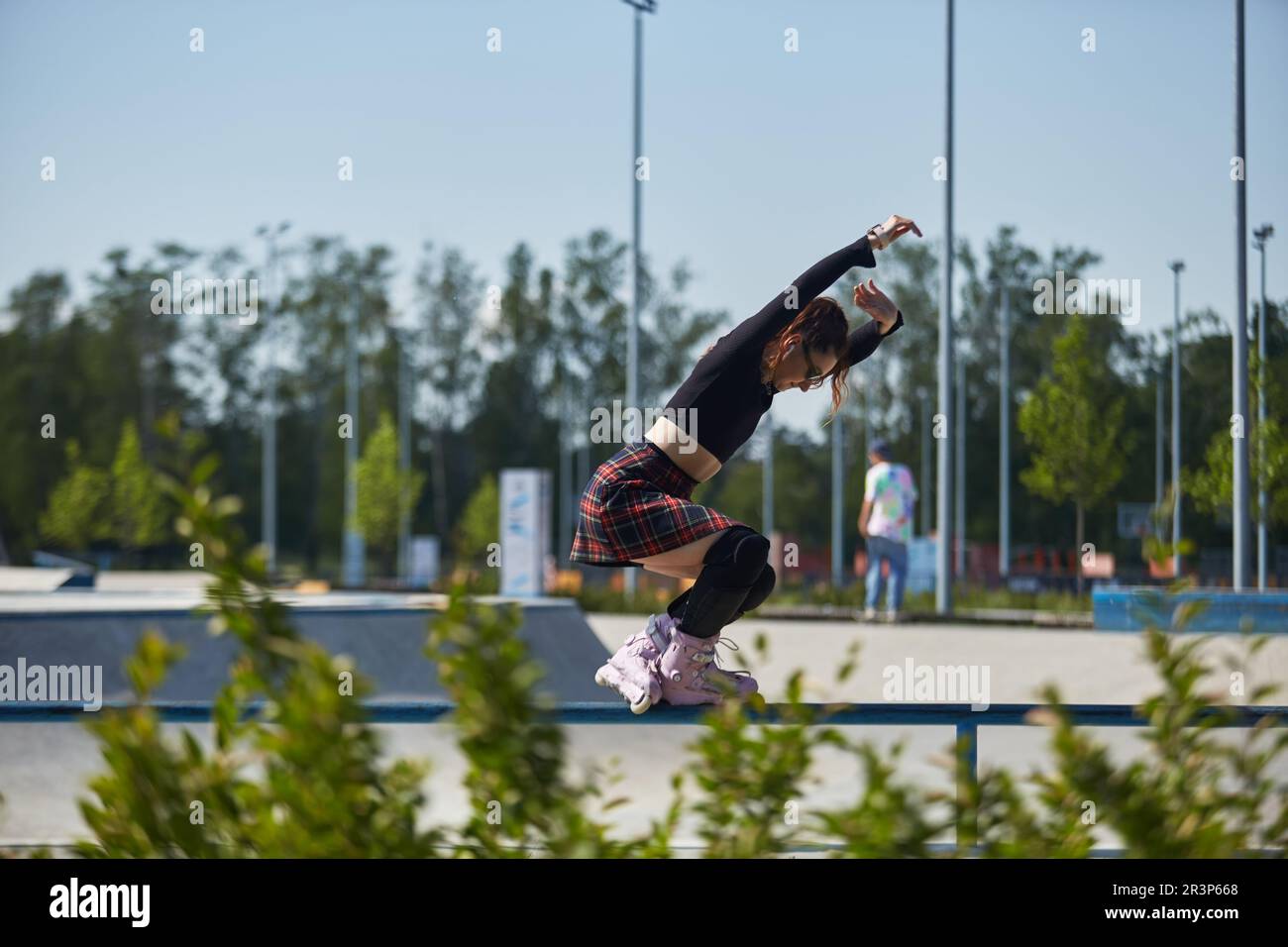 Young roller blader female grinding on a rail in a skatepark. Cool ...