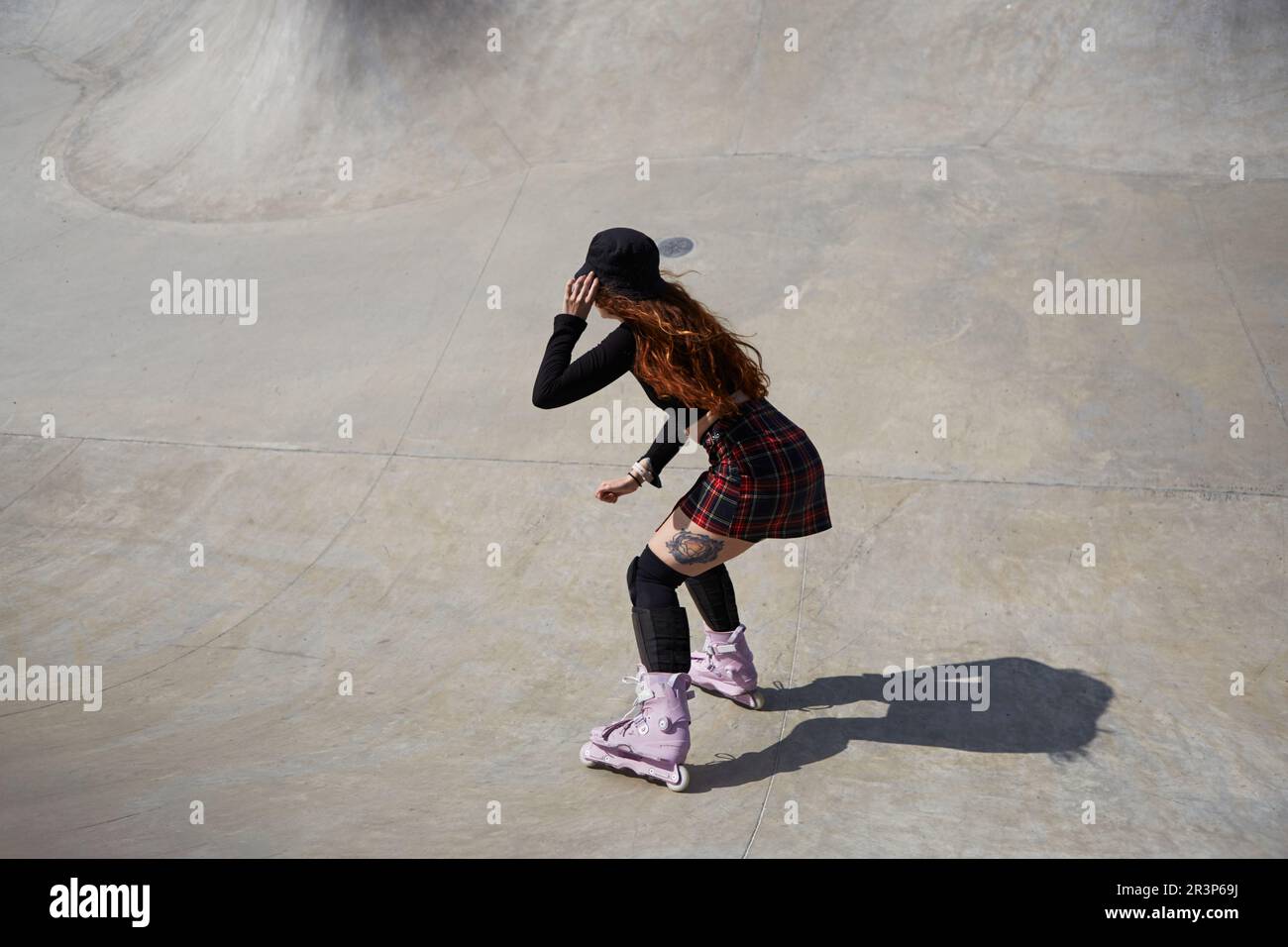 Roller blader female skating in a concrete pool. Aggressive inline ...