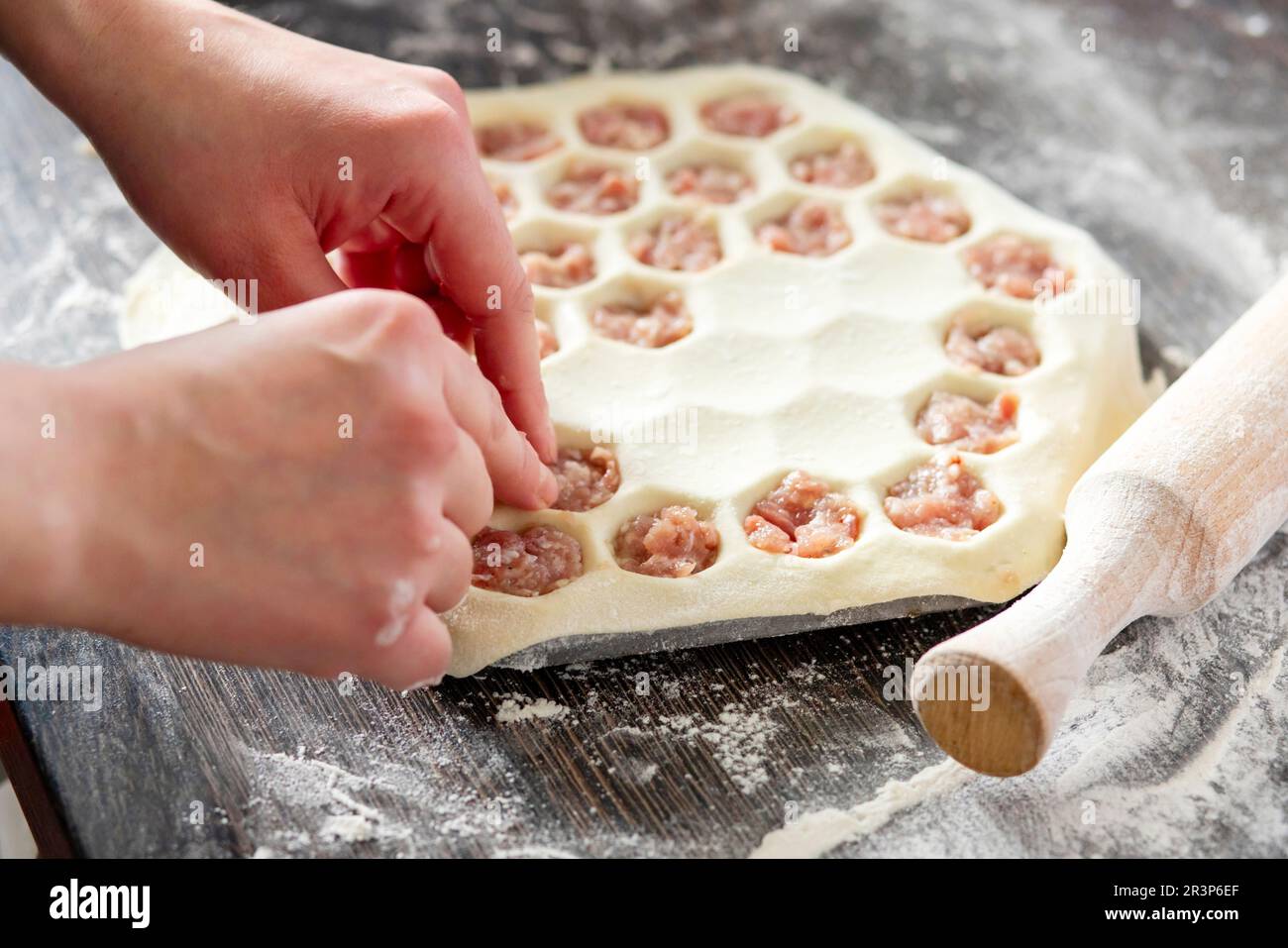 The process of making homemade dumplings. Womans hands sculpting meat ...