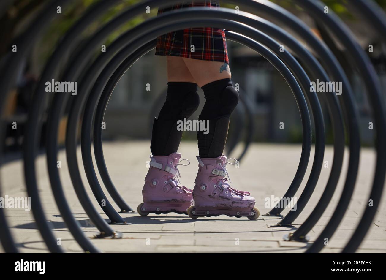 Young girl wearing purple aggressive inline skates in a skatepark ...