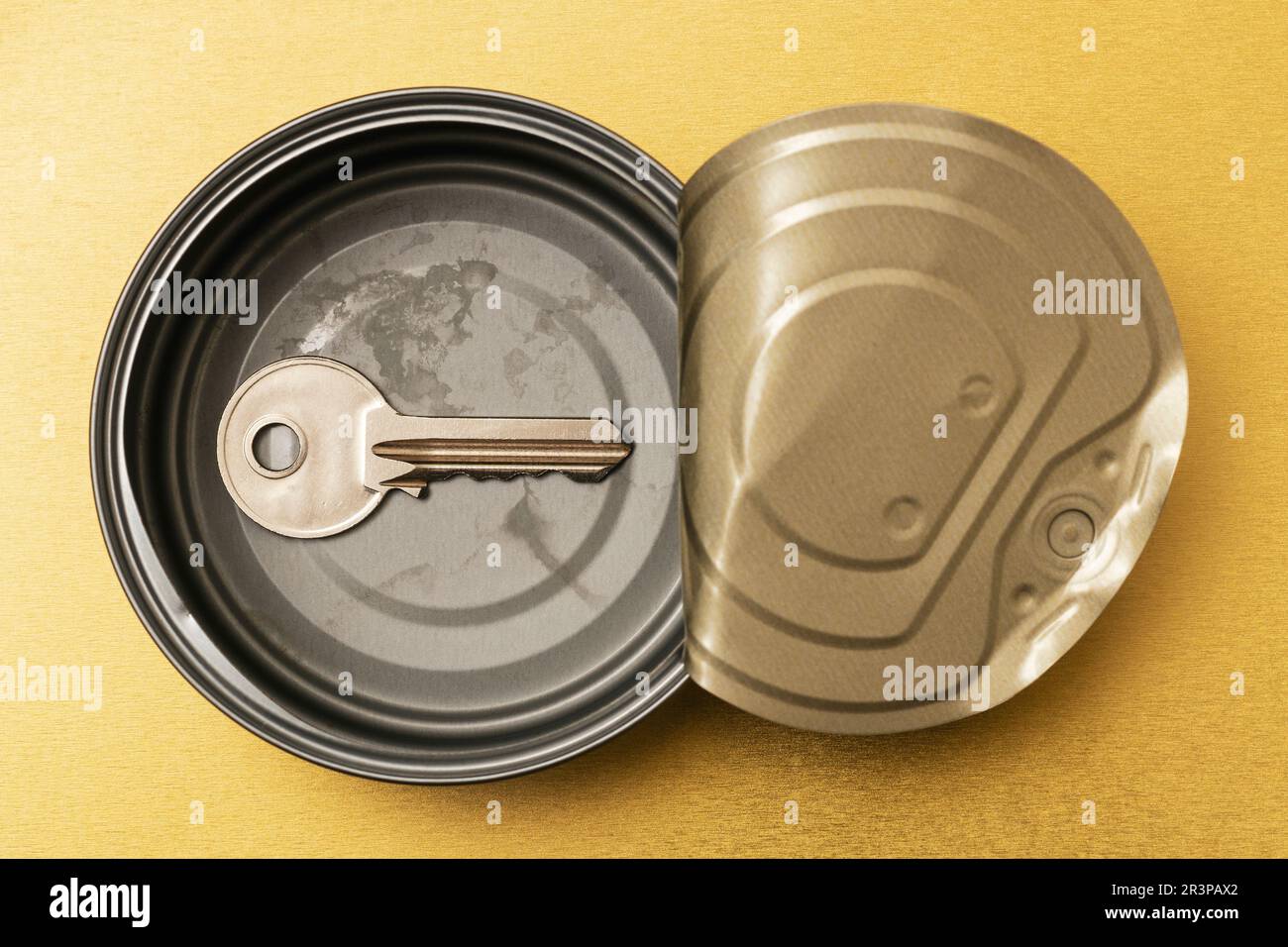 Opened tin can with a door key inside Stock Photo - Alamy