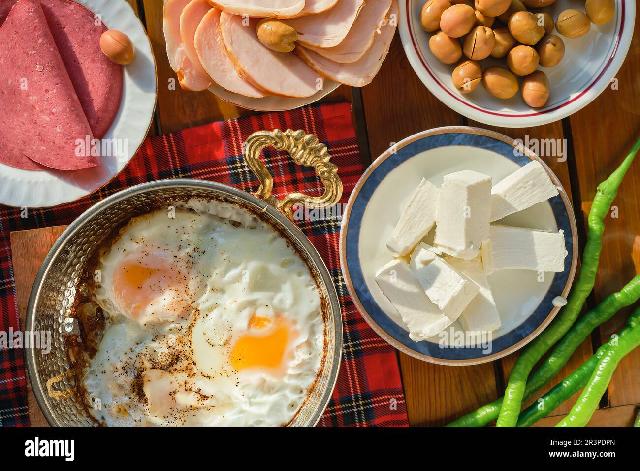 Traditional homemade Turkish breakfast with fried eggs in a copper pan ...