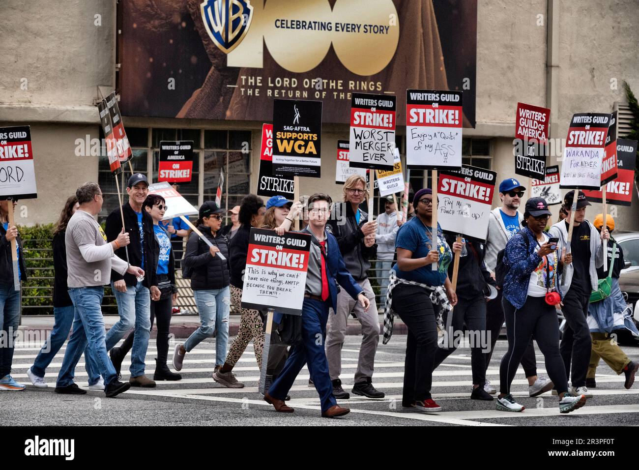 Picketers pass near a studio entrance during a Writers Guild rally ...