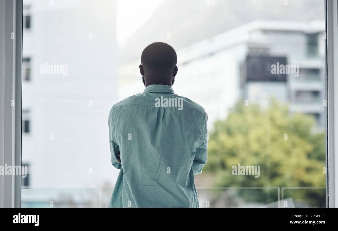 Back, thinking and window with a business black man standing in his ...