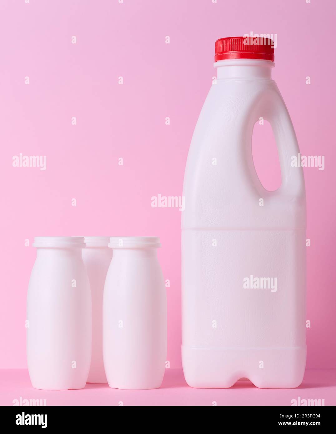 White plastic bottle for milk and dairy products on a pink background ...