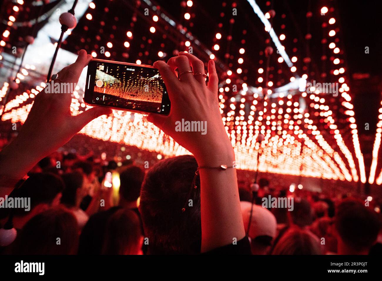 A person takes a photo of Four Tet performing in surround sound with ...