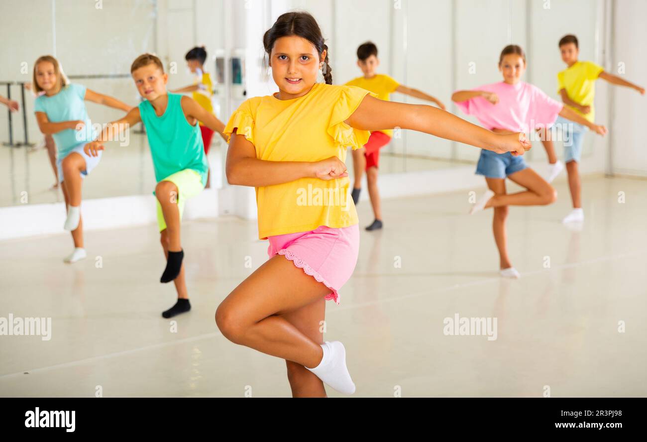 Cheerful preteen hispanic girl learning energetic dance in choreography ...