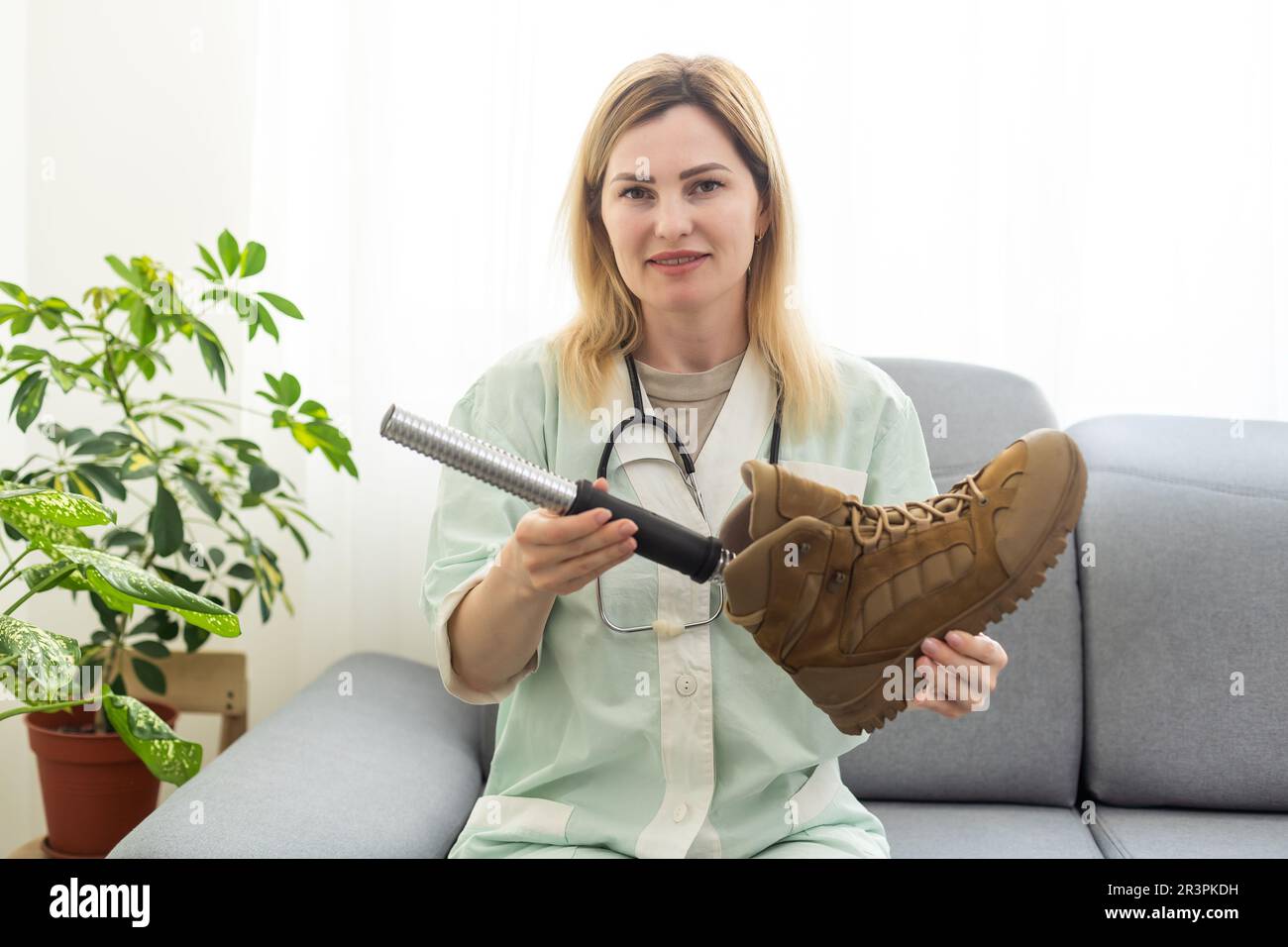 Portrait of young prosthetics technician holding prosthetic leg ...