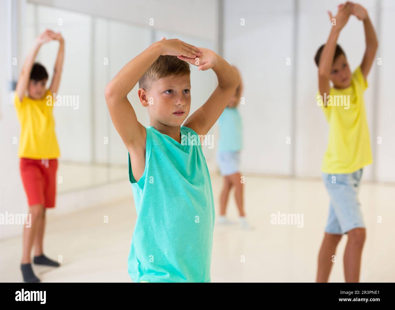 Group of fashionable children learning a modern dance while having ...