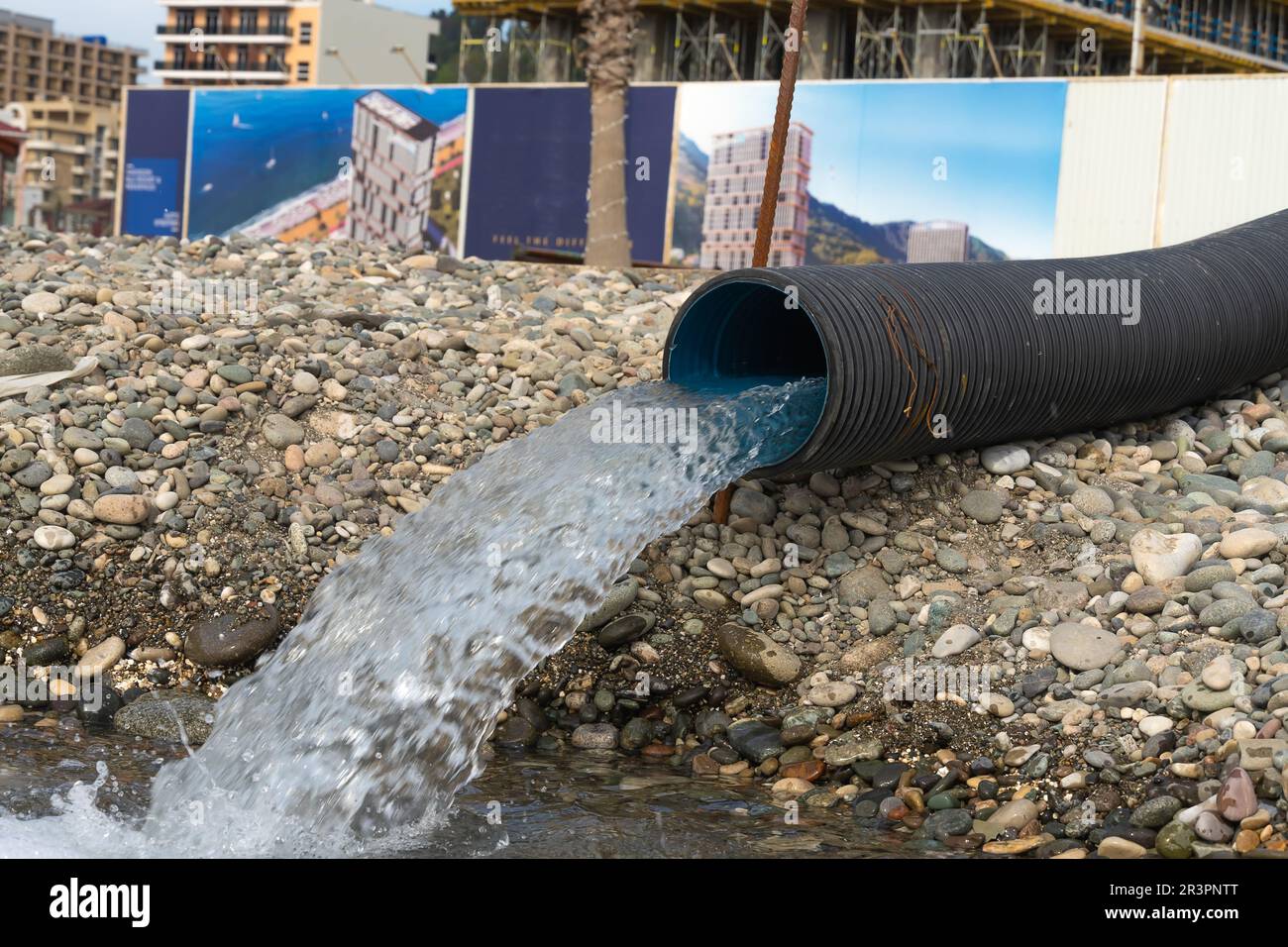 Close-up of a large plastic water pipe with a large stream of water ...