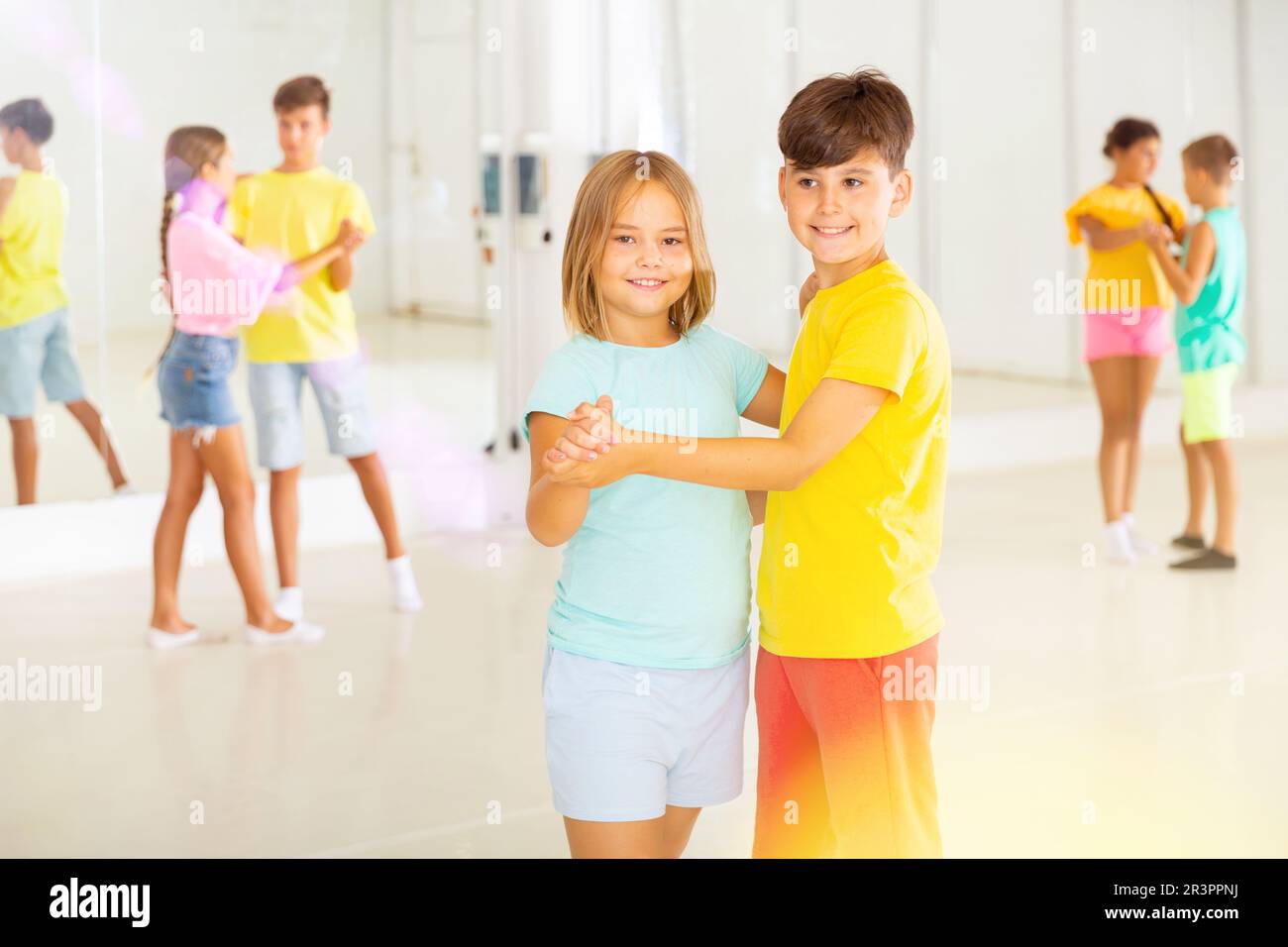 Tween boy and girl practicing slow pair dancing during group class ...