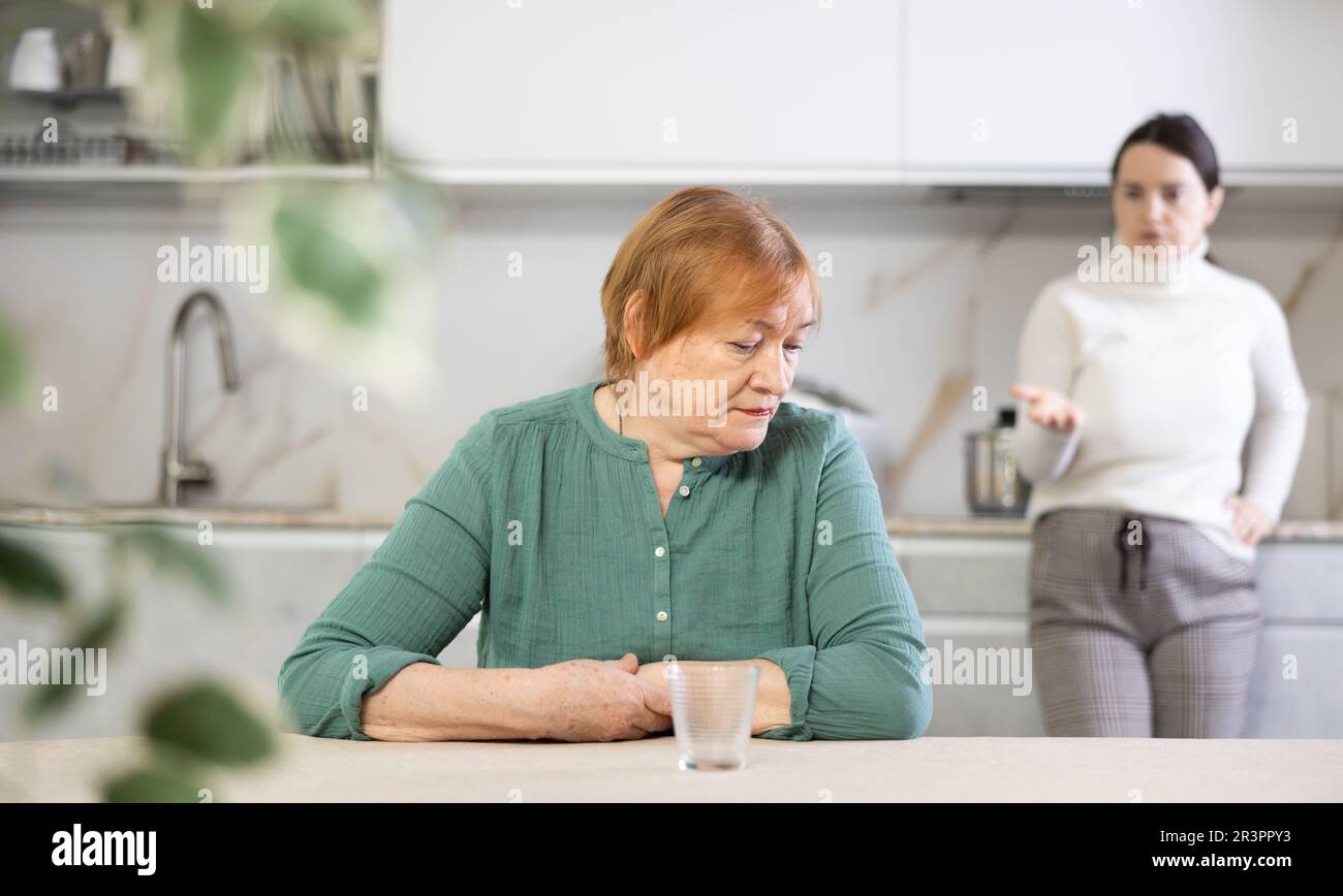 Frustrated elderly mother having tense conversation with her daughter ...