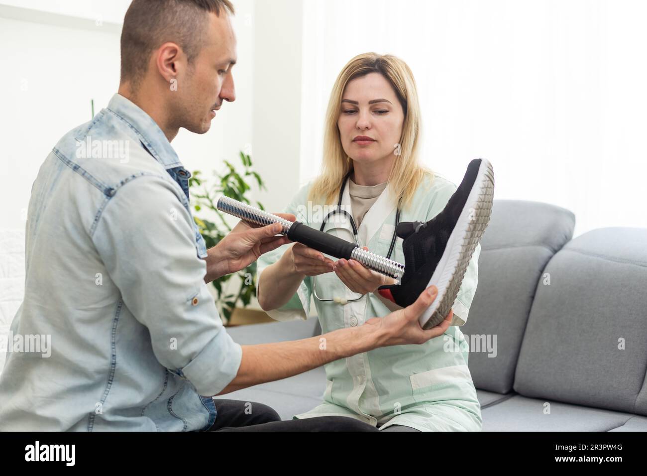 Assisted woman physiotherapist take care man with prosthetic leg and ...