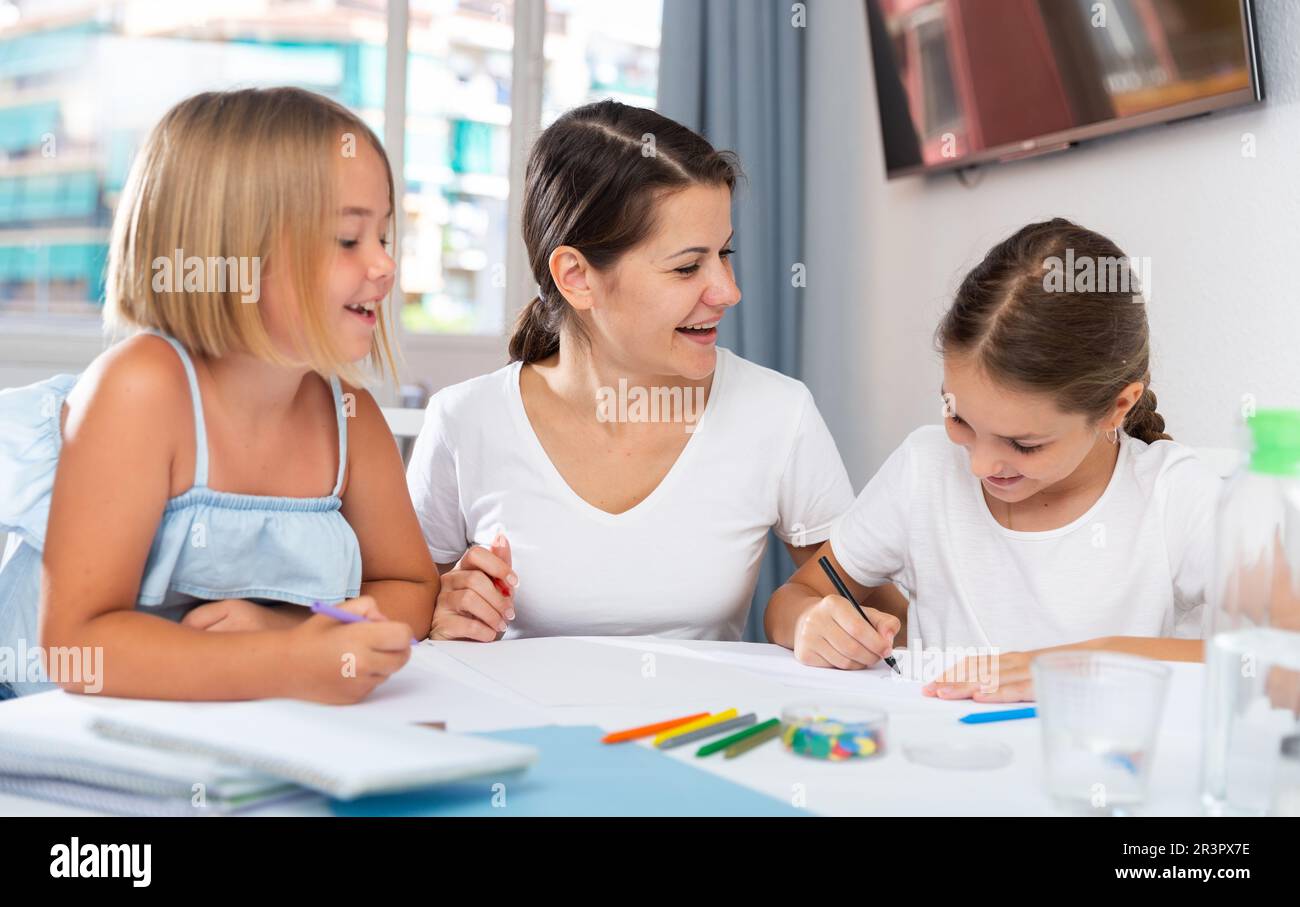 Young woman and two daughters drawing together Stock Photo - Alamy