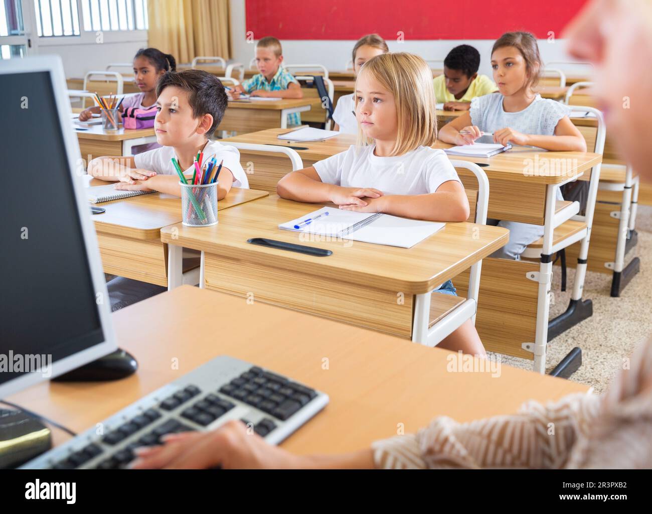 Diligent tweens studying in classroom with female teacher Stock Photo ...