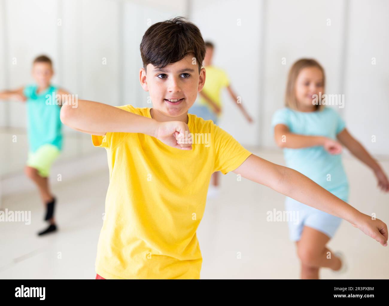 Group of fashionable children learning a modern dance while having ...