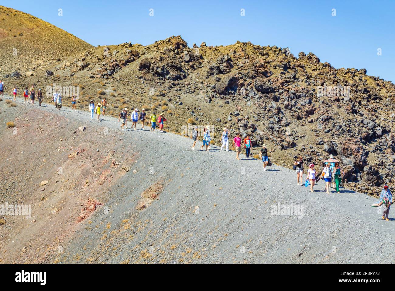 Tourists hiking to the active volcano- highlight of Santorini and ...