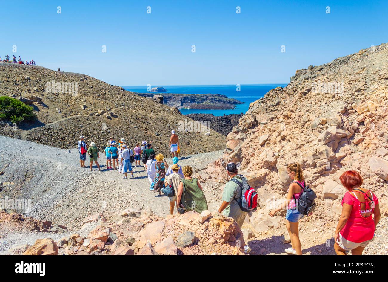 Tourists hiking to the active volcano- highlight of Santorini and ...