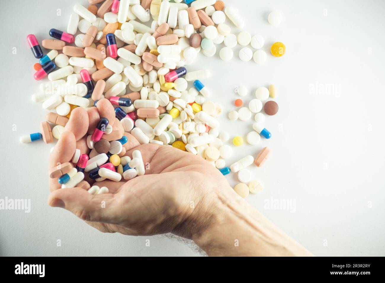 Medicine capsules laid out on a table with a hand on them. Health ...