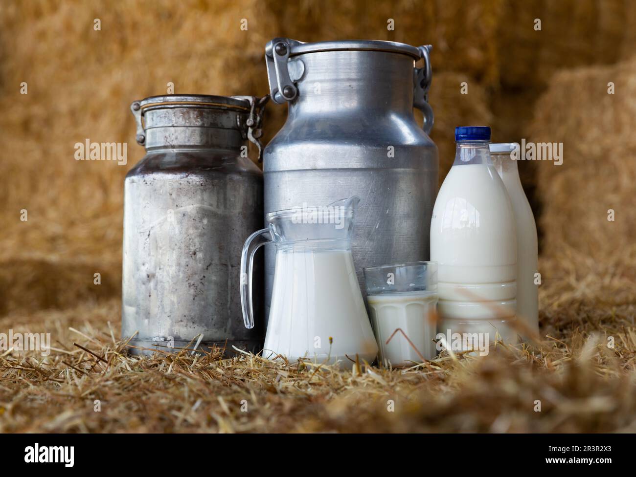 Fresh natural milk in decanter and cans on farm hayloft Stock Photo - Alamy