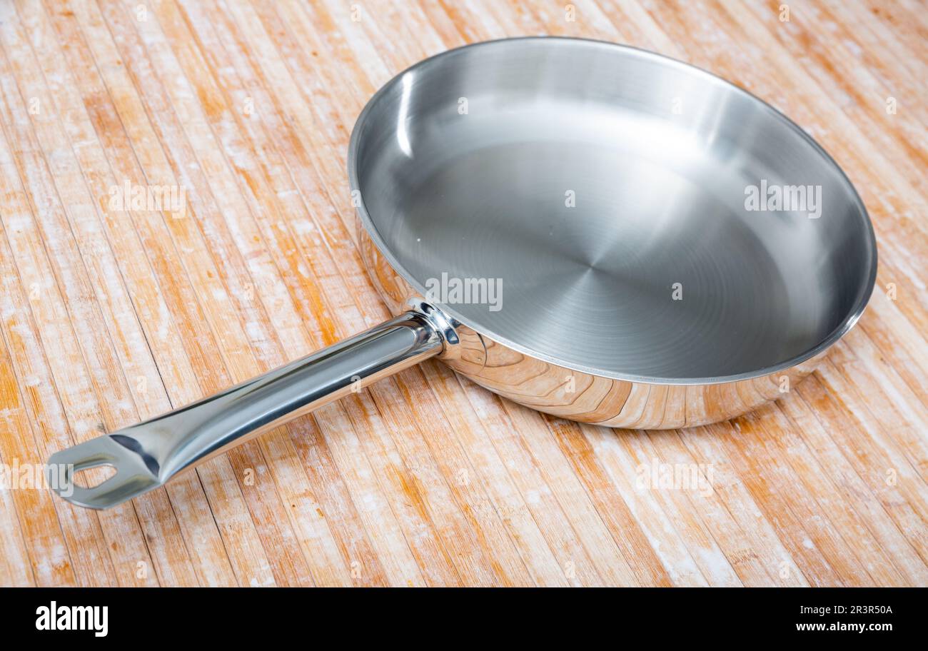 New shiny stainless steel frying pan Stock Photo - Alamy