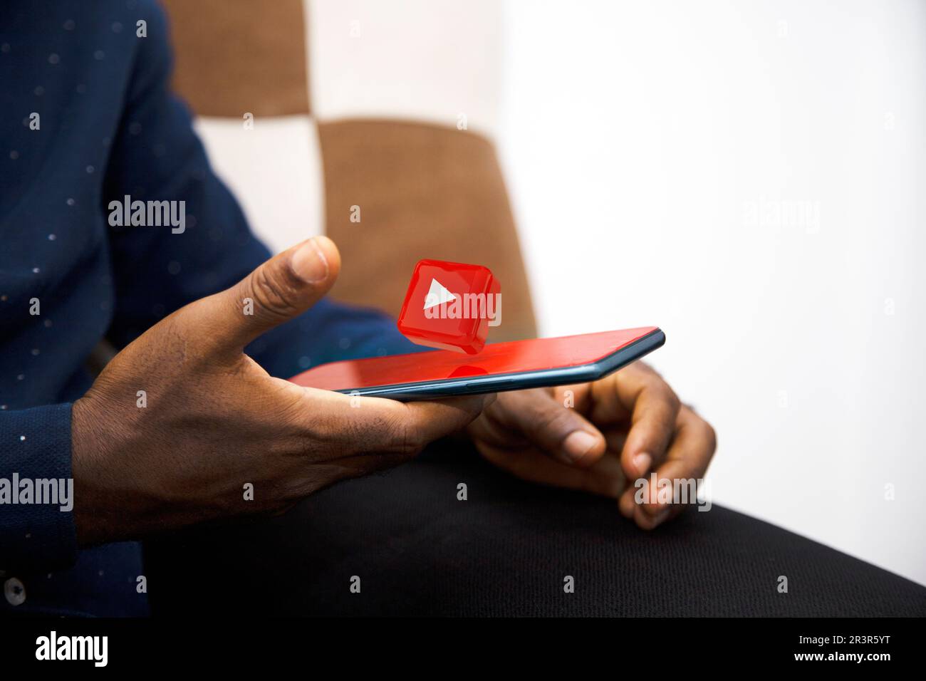 Black Hand holding mobile phone with YouTube logo hovering on screen in ...