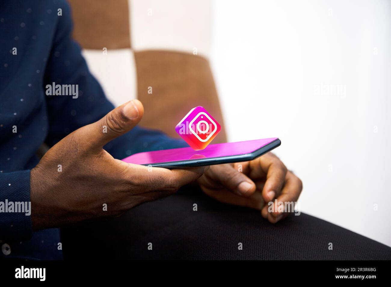 Black Hand holding mobile phone with Instagram logo hovering on screen ...