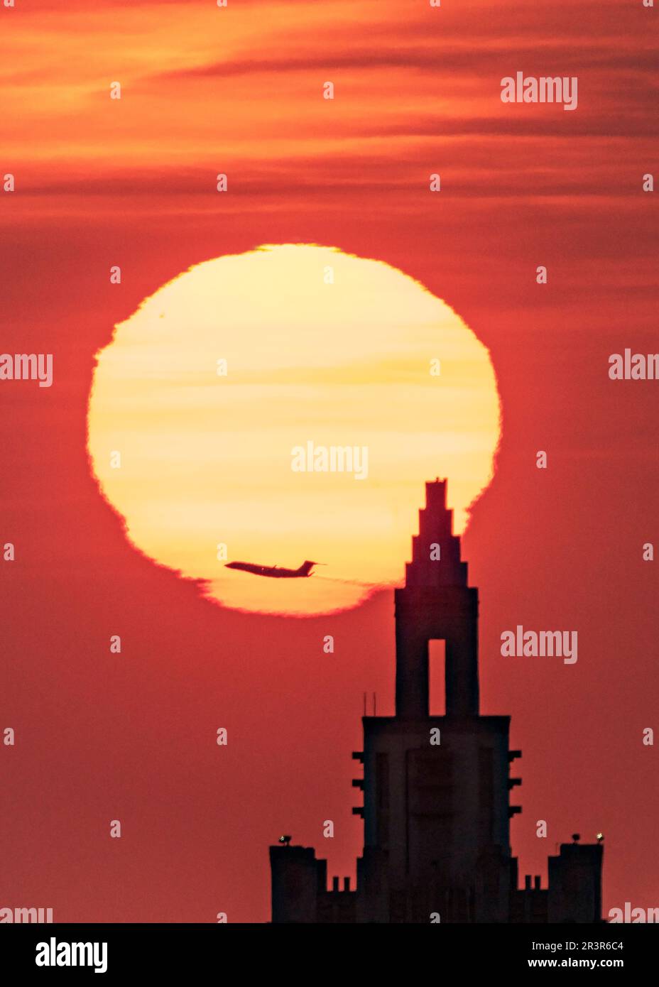 Huge sun setting between New York City towers Stock Photo - Alamy