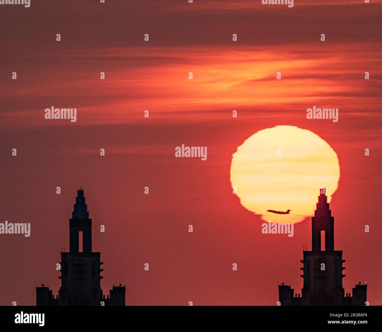 Huge sun setting between New York City towers Stock Photo - Alamy