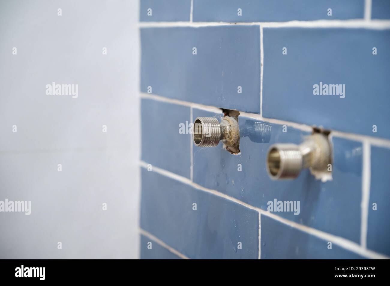 Installation of water tap in bathroom. Installs shower system Stock ...