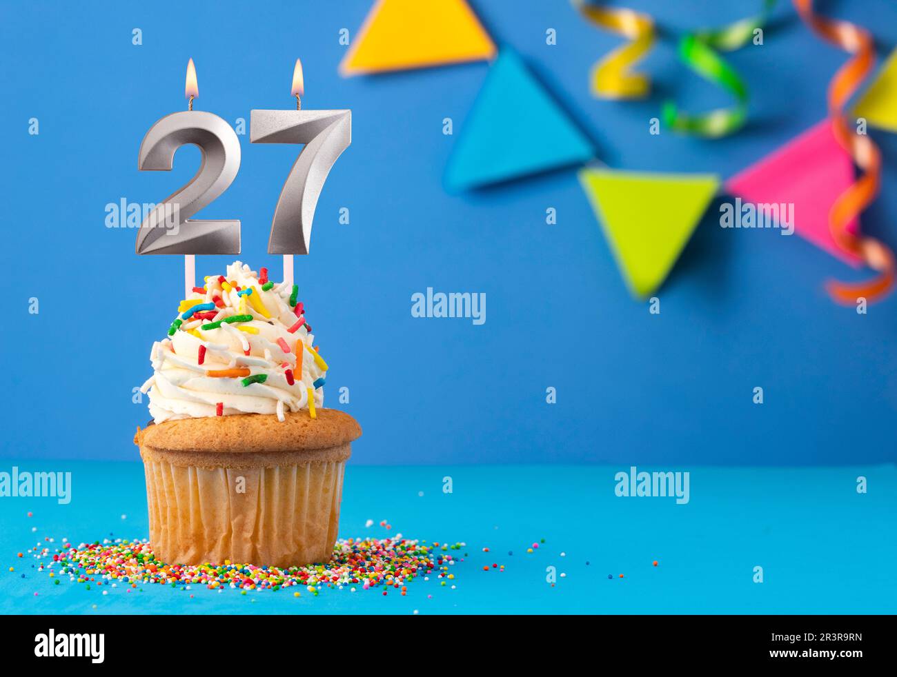 Birthday cake with candle number 27 - Blue background Stock Photo - Alamy