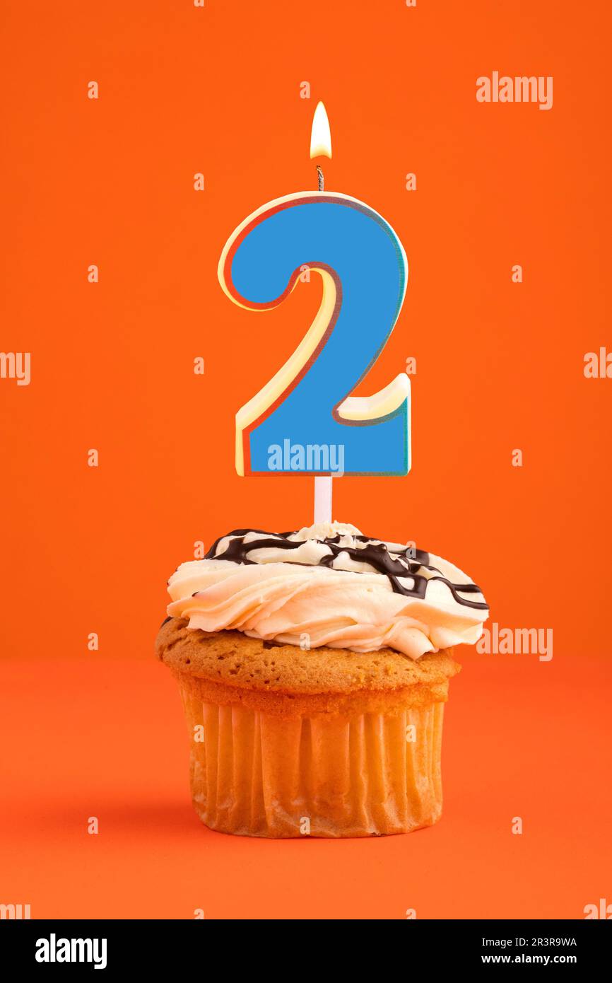 Birthday cake with number 2 blue candle - orange background Stock Photo ...